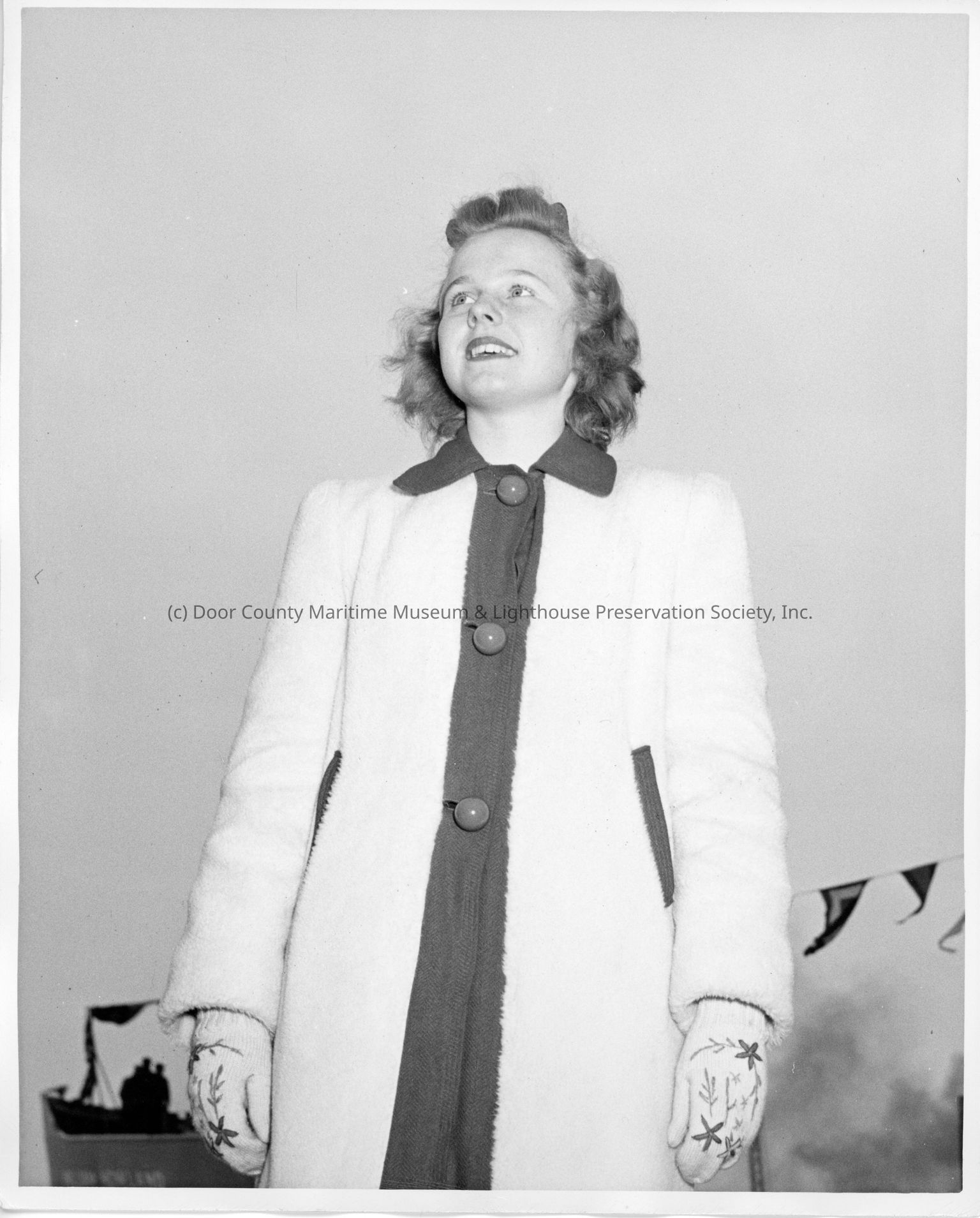 Patsy Smith wearing white coat with floral decorated gloves