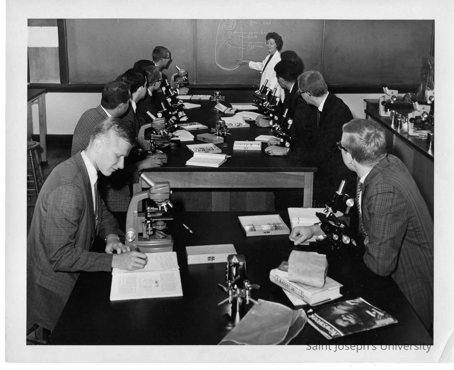 Biology professor, Catherine Nash, teaching class in science laboratory ...